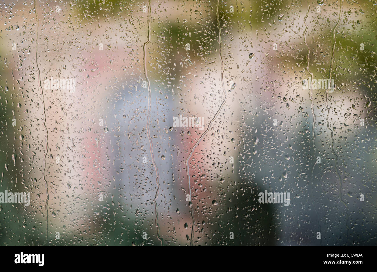 Raindrops on window with colorful background Stock Photo - Alamy