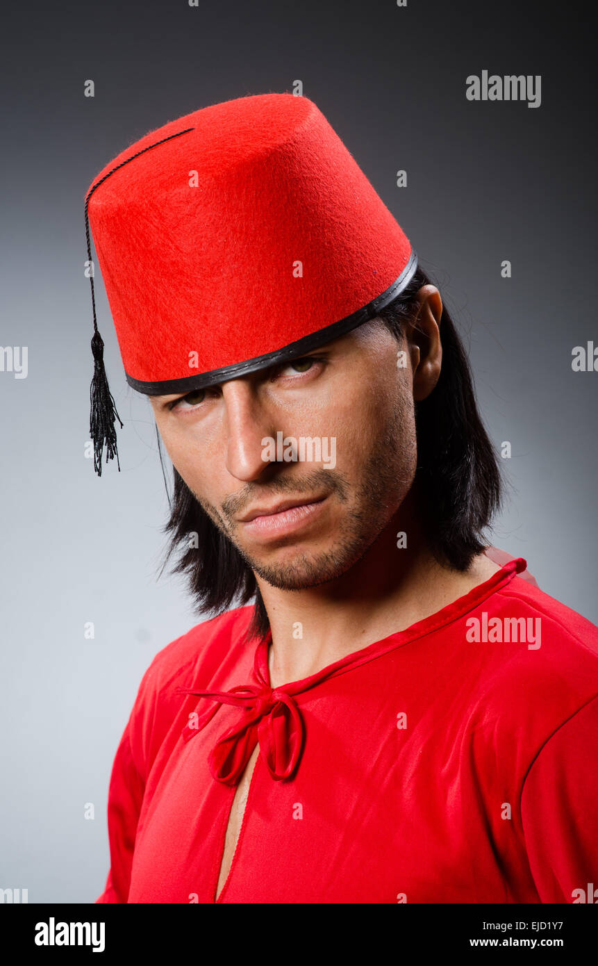 Funny man in red dress wearing fez hat Stock Photo - Alamy