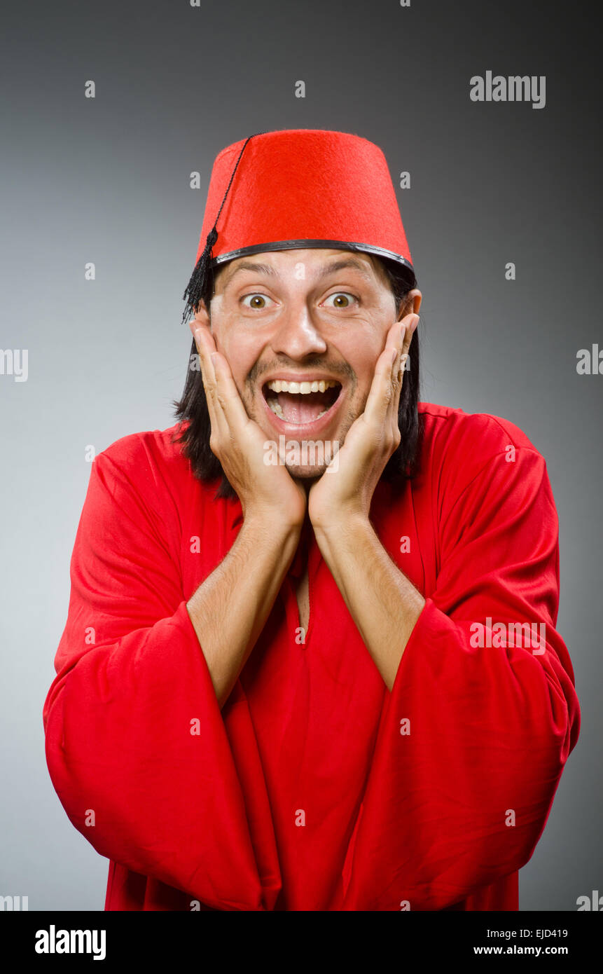 Funny man in red dress wearing fez hat Stock Photo - Alamy