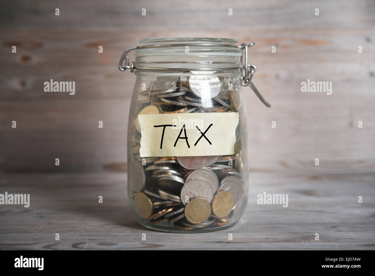 Coins in glass money jar with tax label, financial concept. Vintage ...