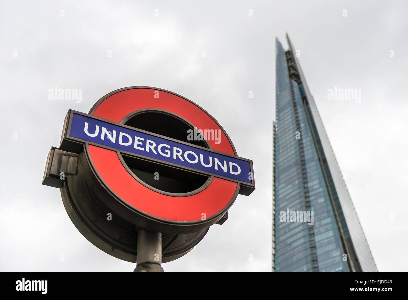 A London Underground station sign shown with the Shard de-focused in ...