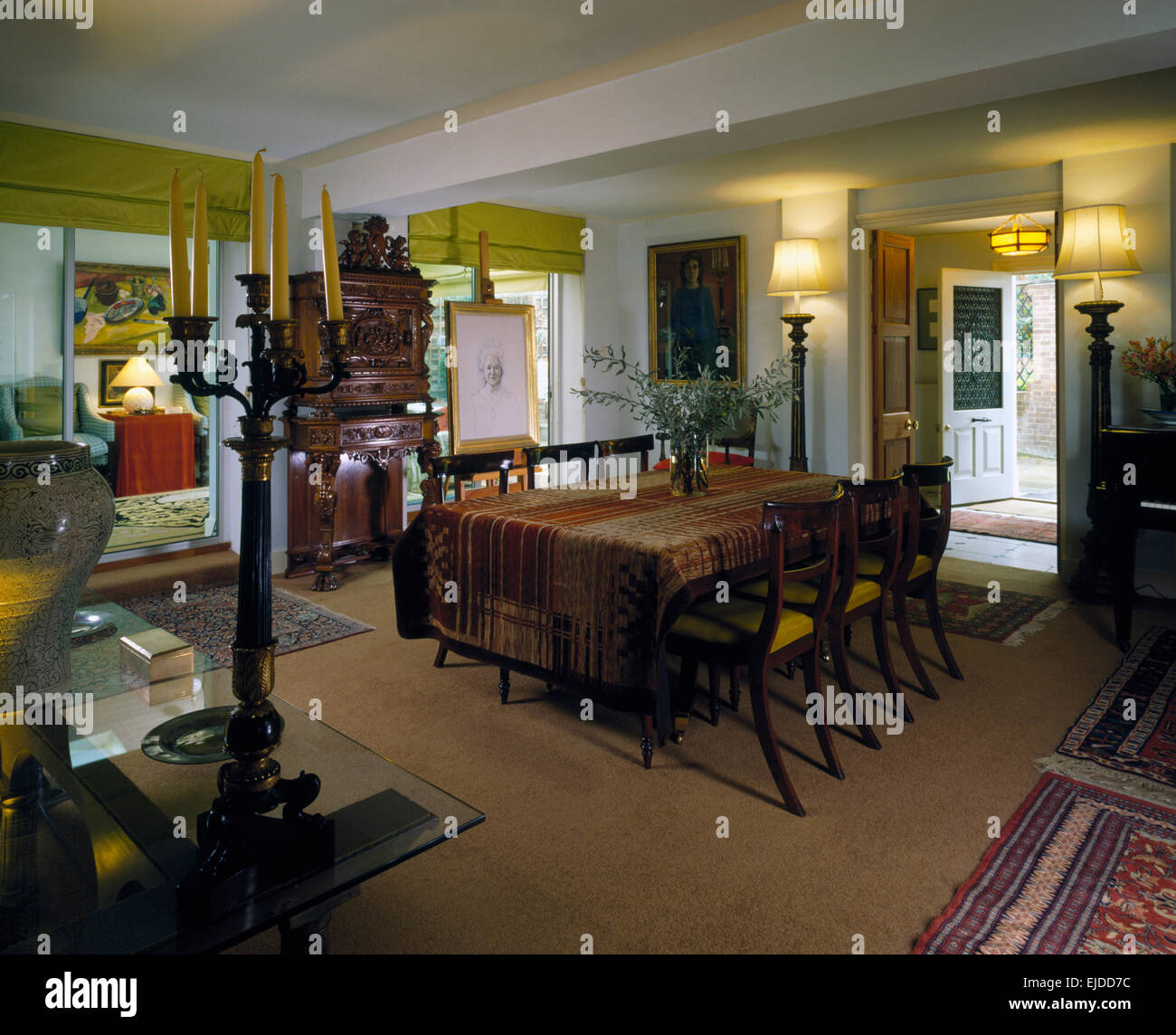 Table covered with a patterned rug in Victorian style dining room with ...