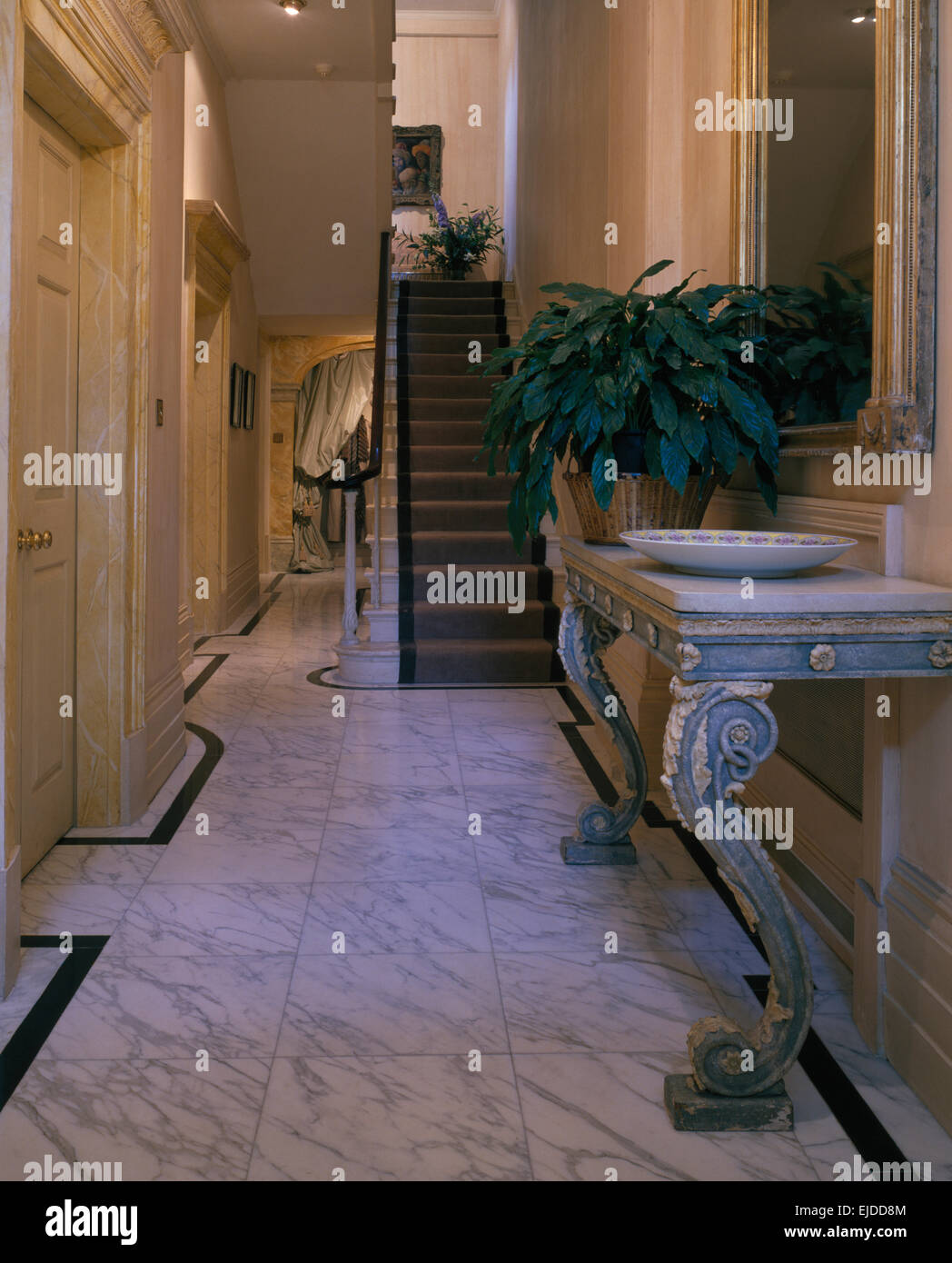 Marble tiled floor and painted console table in an opulent nineties ...