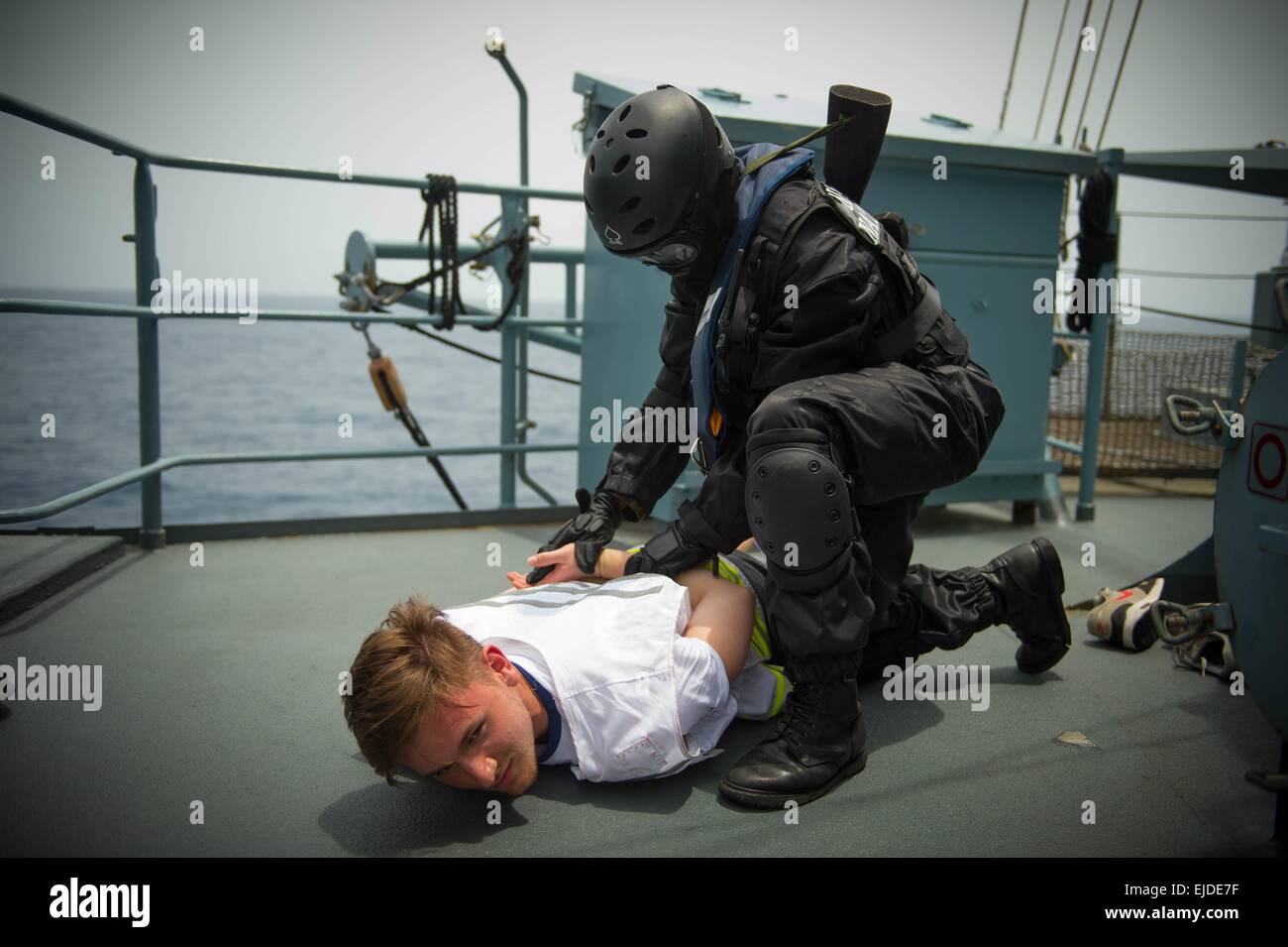 An Ivory Coast special operations commando restrains a sailor on the ...