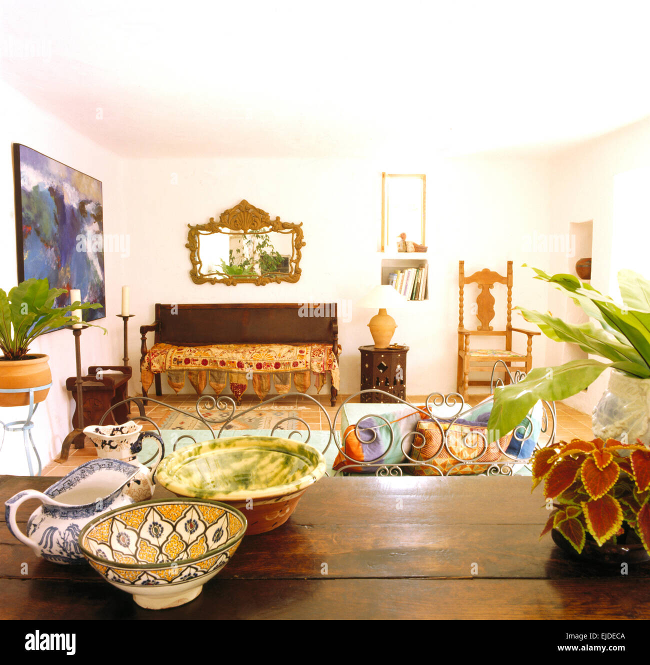 Colorful rustic pottery bowls on table in simple Mallorcan cottage ...