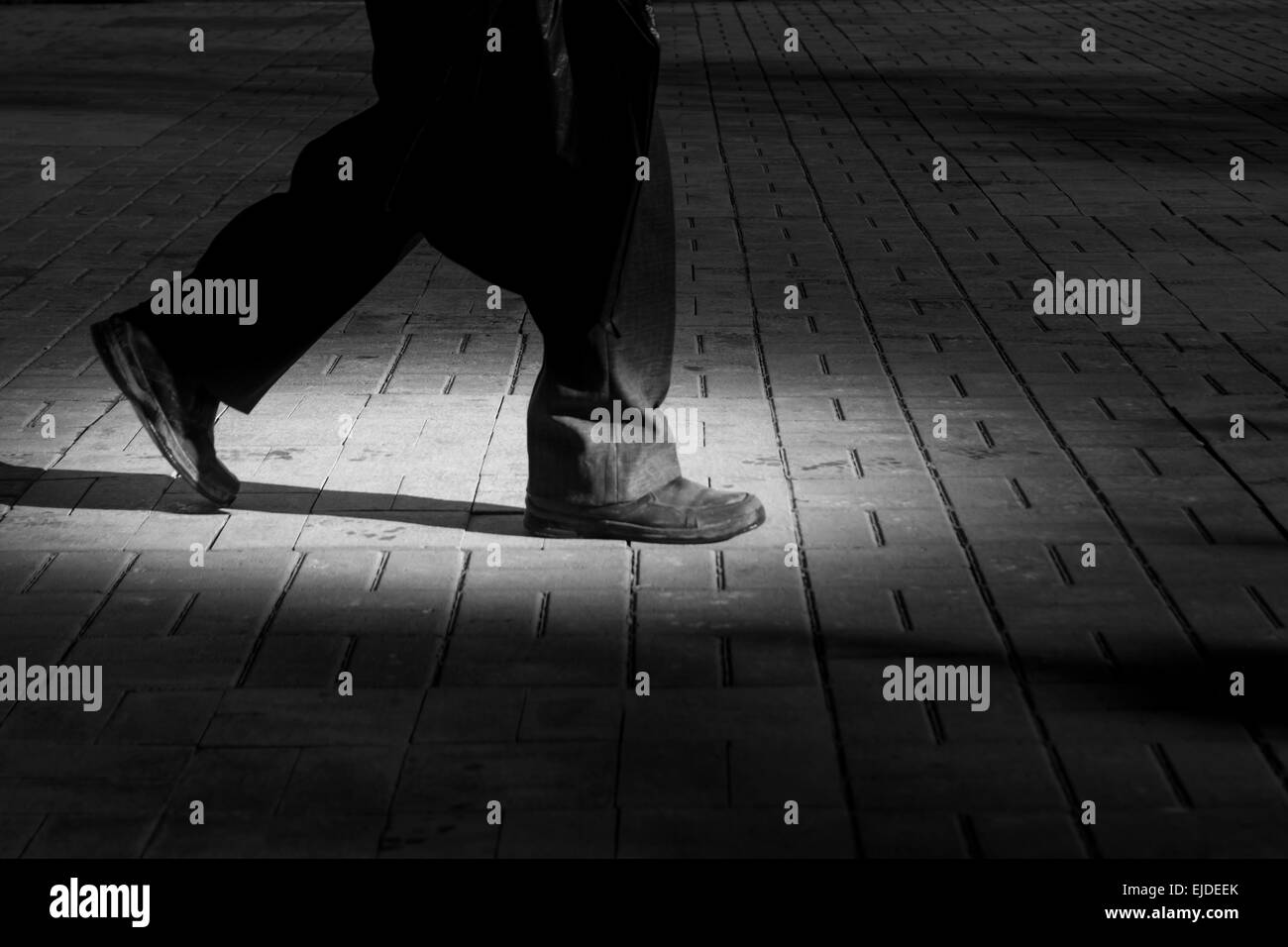 A single old man walks alone on a city pavement Stock Photo - Alamy