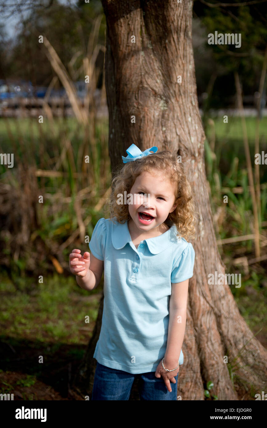 Young girl leaning against oak tree, portrait Stock Photo - Alamy
