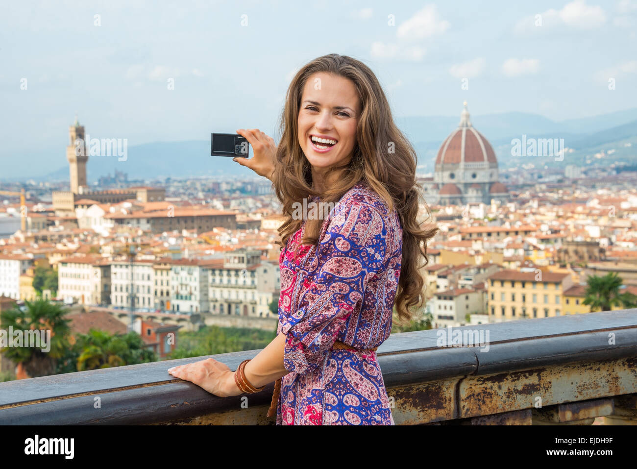Happy young woman taking photo of panoramic view of florence, italy ...