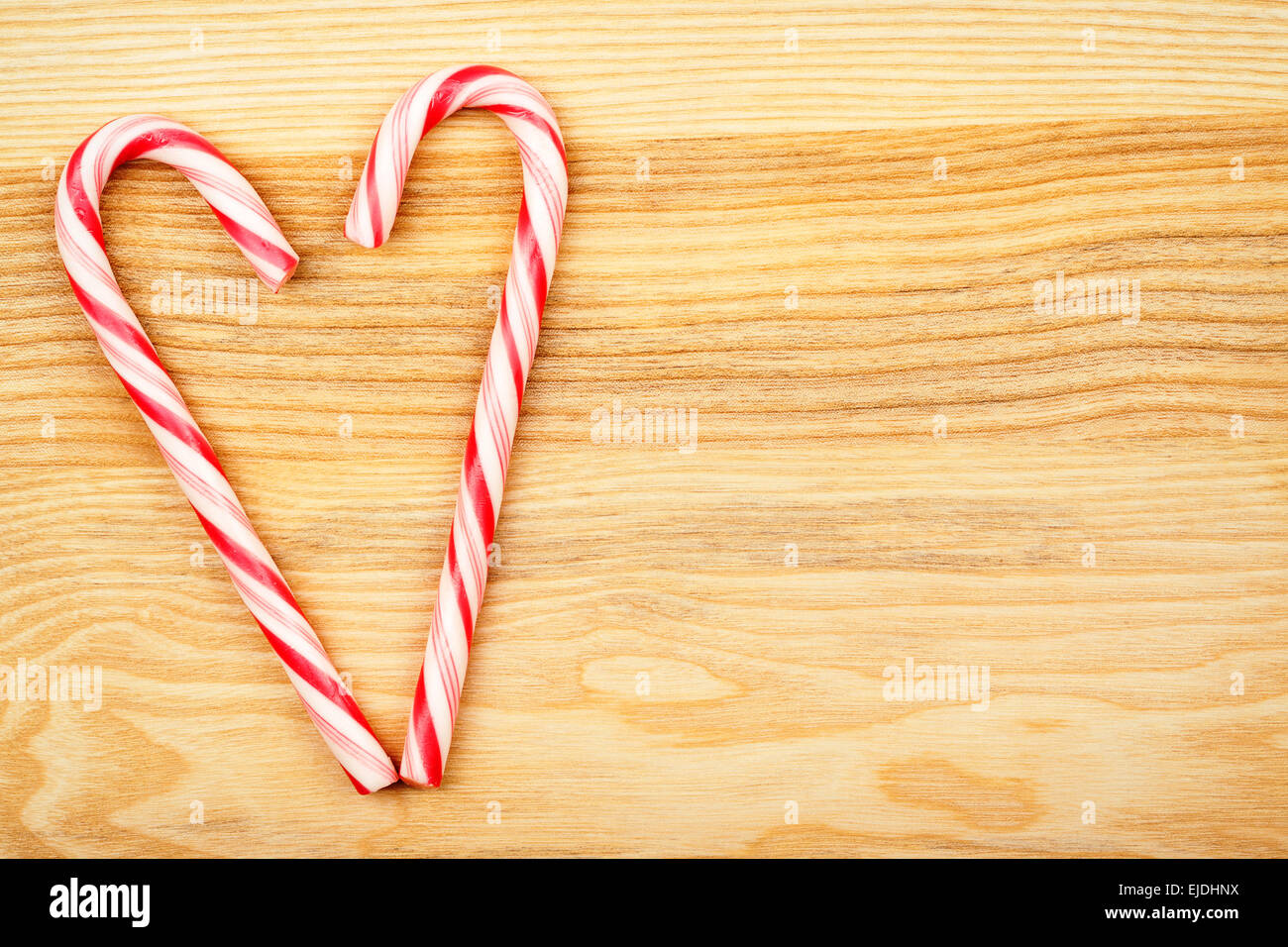 Christmas candy canes on wood texture Stock Photo - Alamy