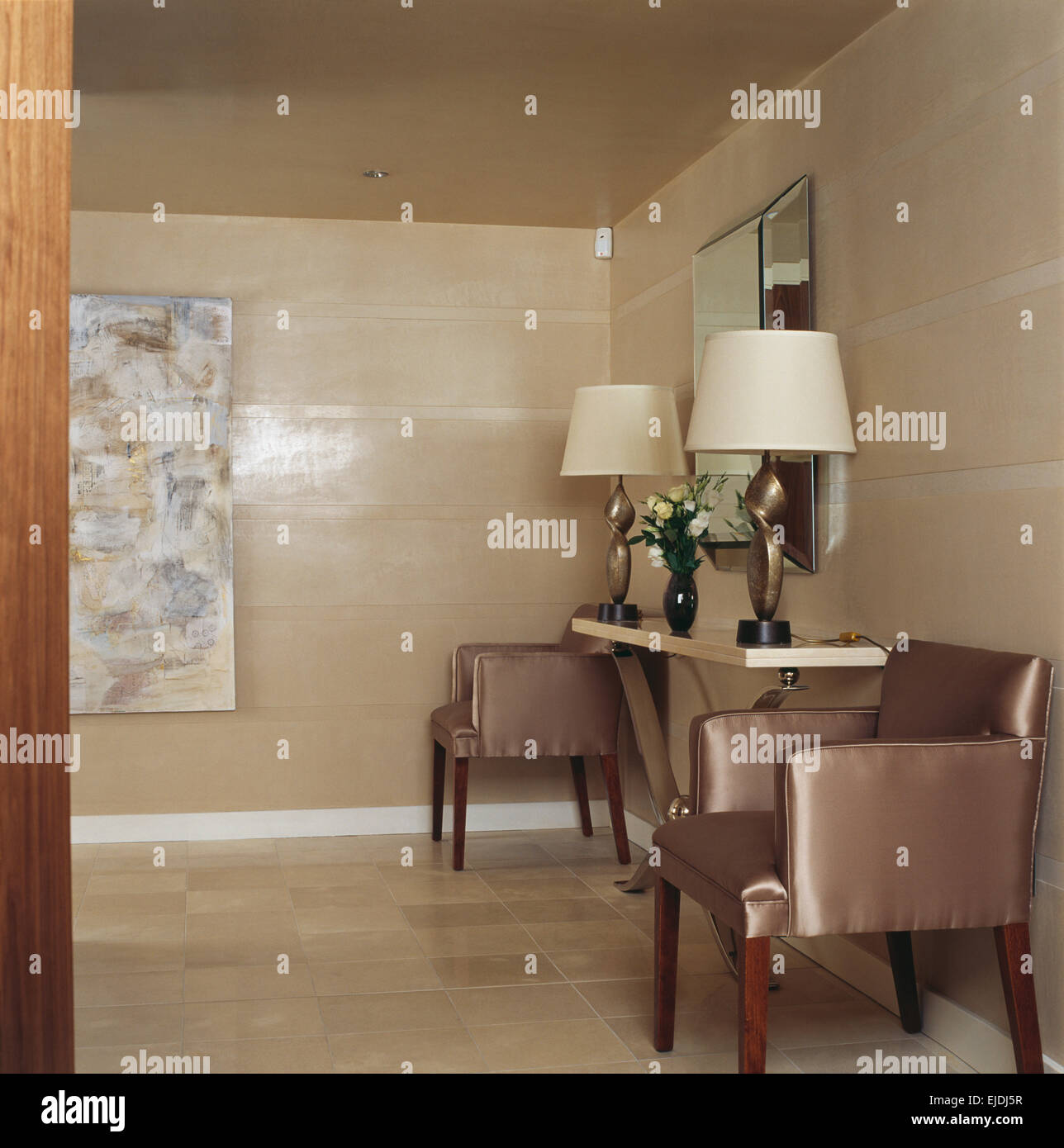 Satin upholstered chairs on either side of console table with white ...