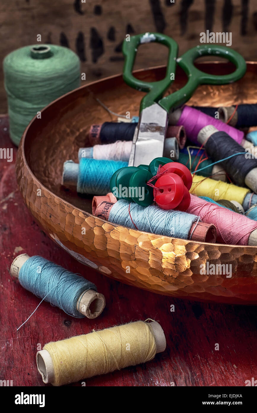 threads and other tools dressmaker in vintage style on wooden surface ...