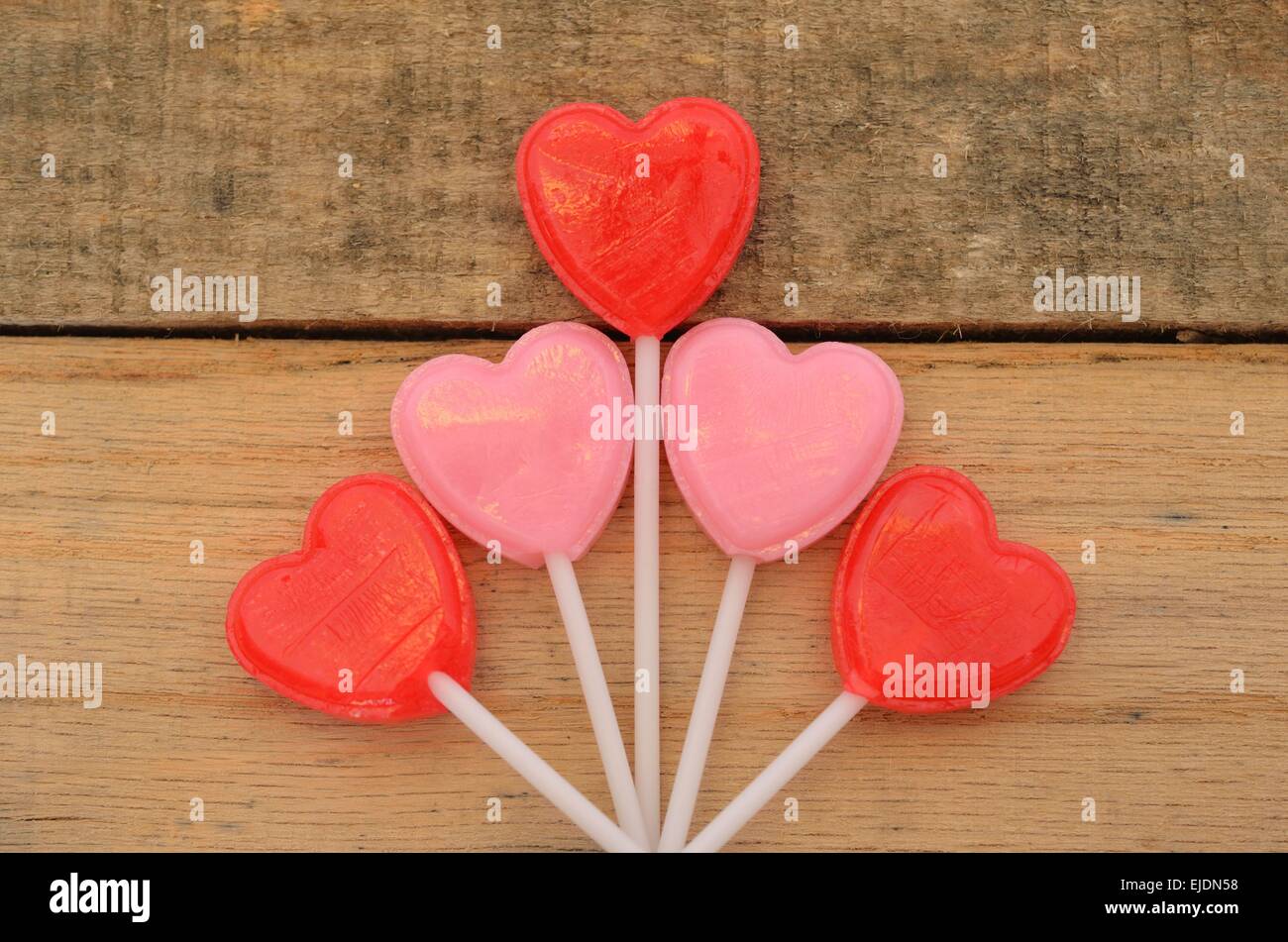 Heart shaped lollipops displayed on pallet wood background. Festive fun ...