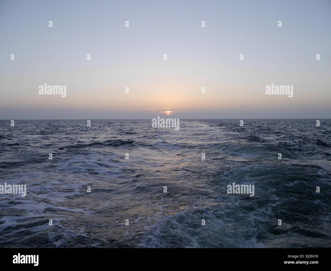 ship trails in open sea on sunrise background Stock Photo - Alamy