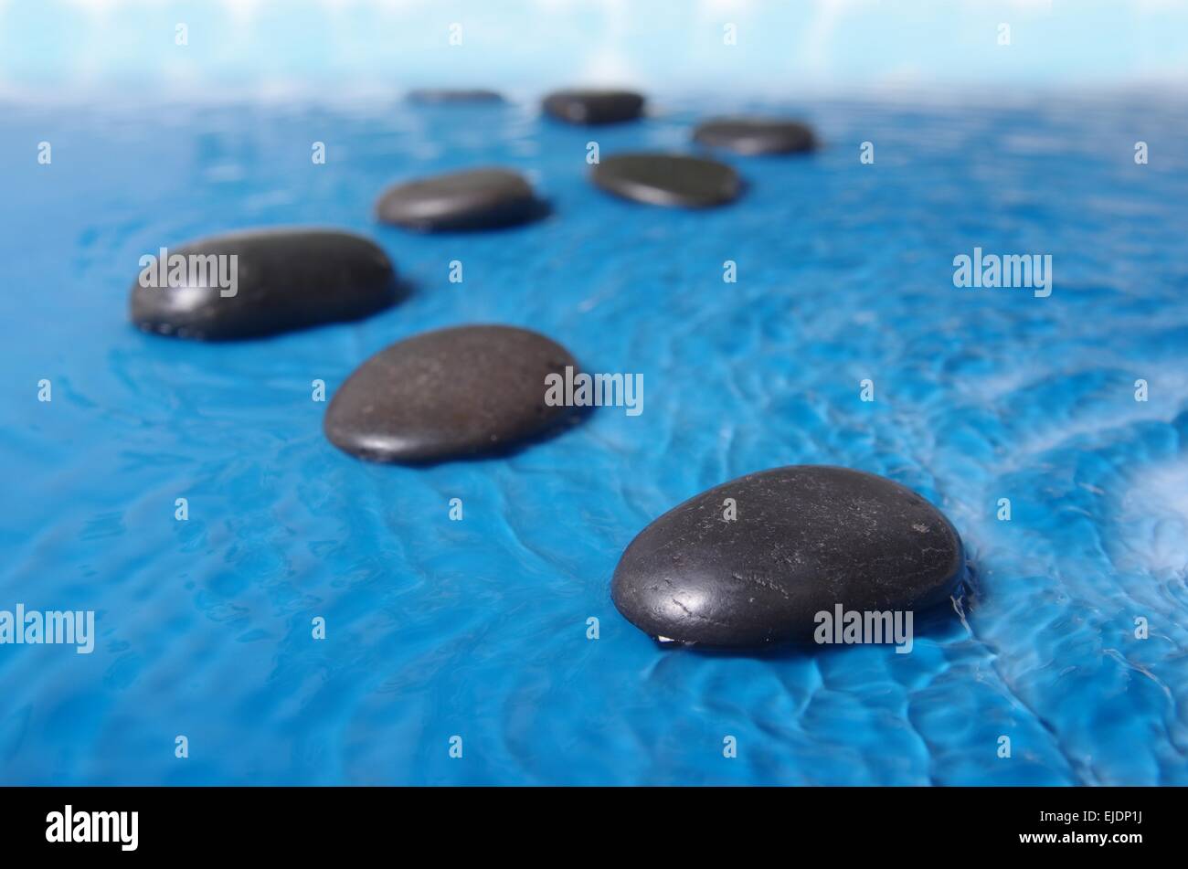 zen stones in blue water with waves Stock Photo - Alamy