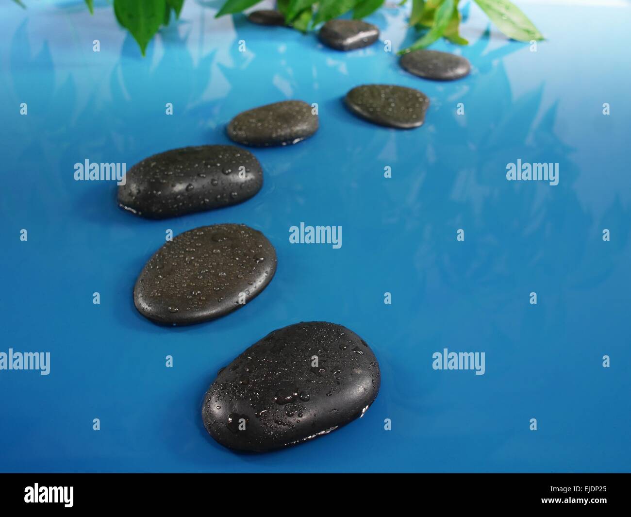 zen stones in blue water with waves Stock Photo - Alamy