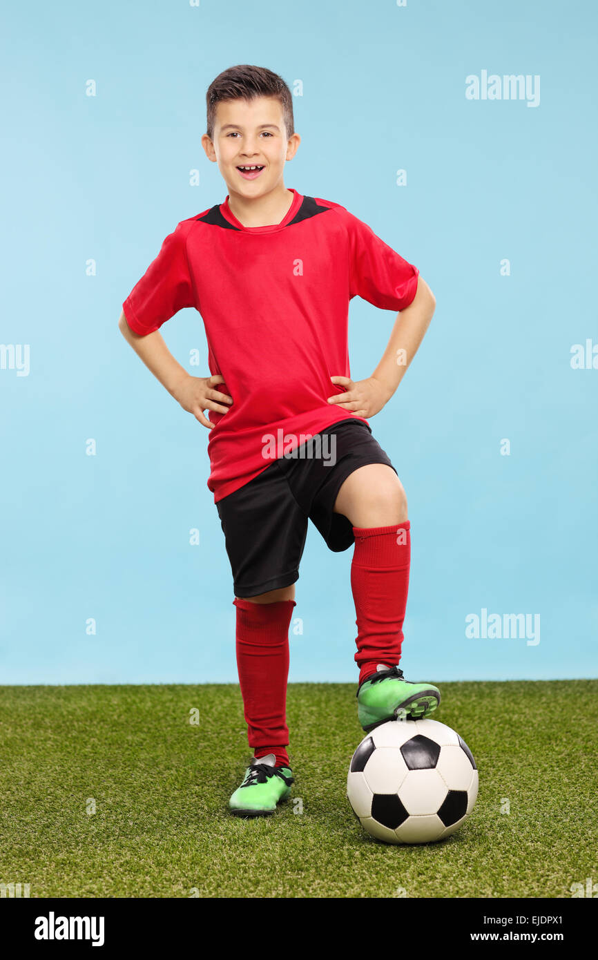 Full length portrait of a junior in a soccer uniform standing over a ...