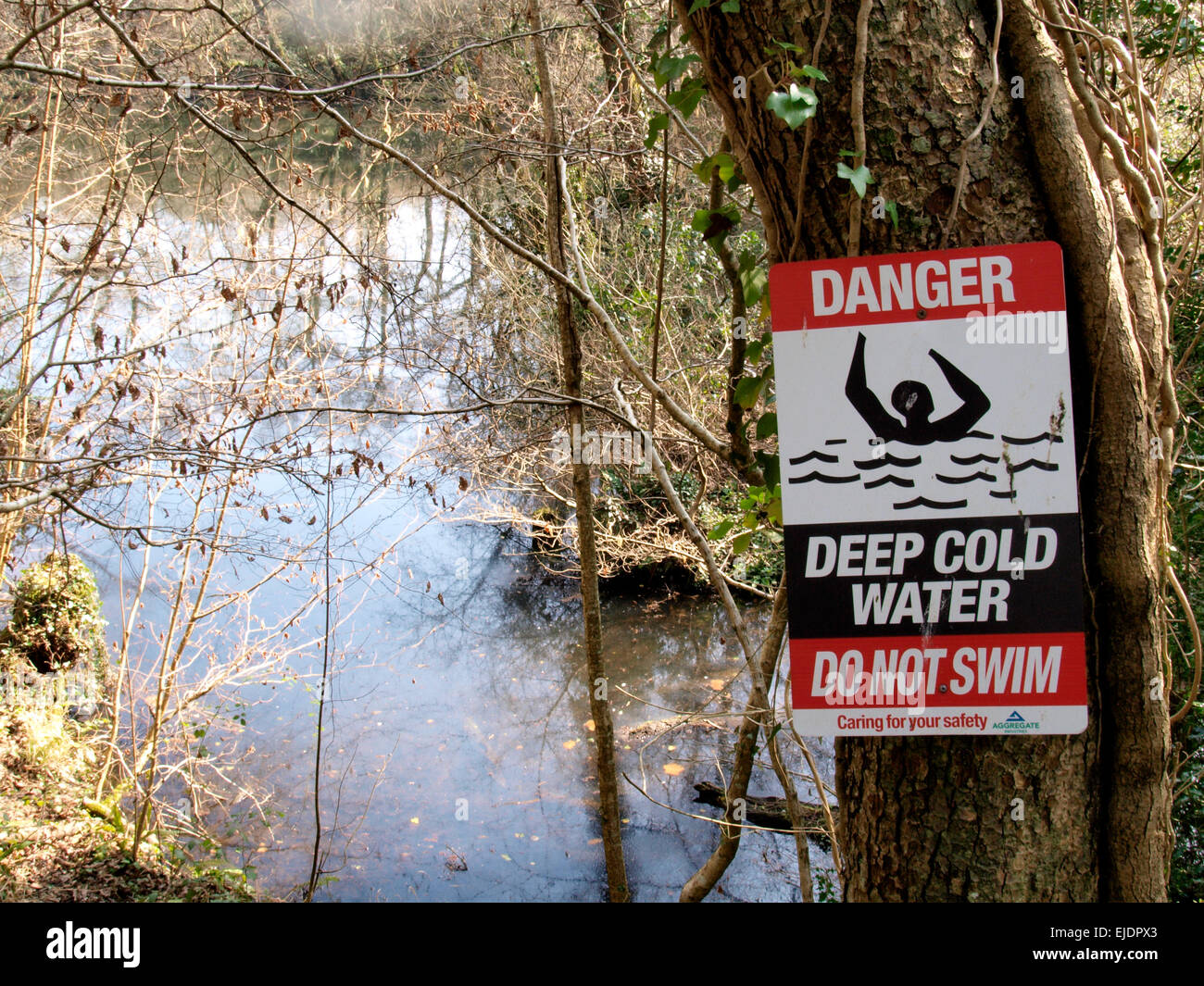 Danger deep cold water do not swim sign nailed to a tree above a ...