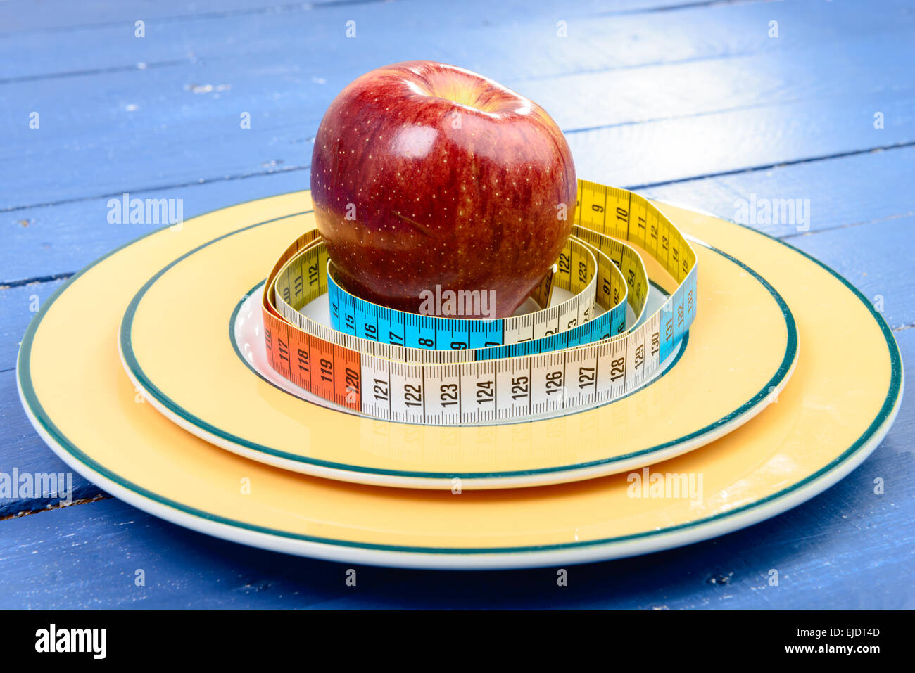 one meter ribbon around apple in the plate on the blue table Stock ...