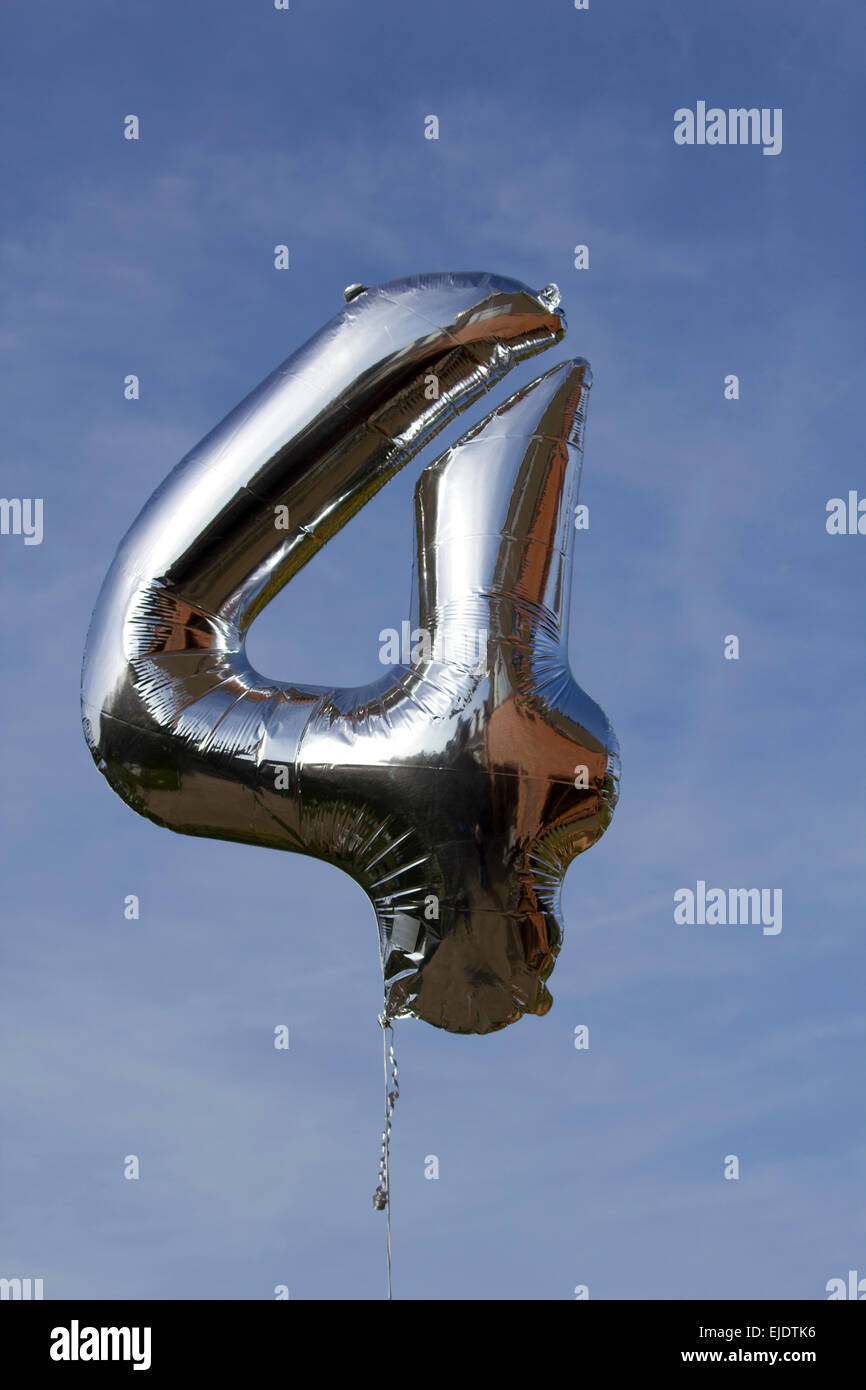 Number 4, four balloon floating against a blue sky Stock Photo - Alamy