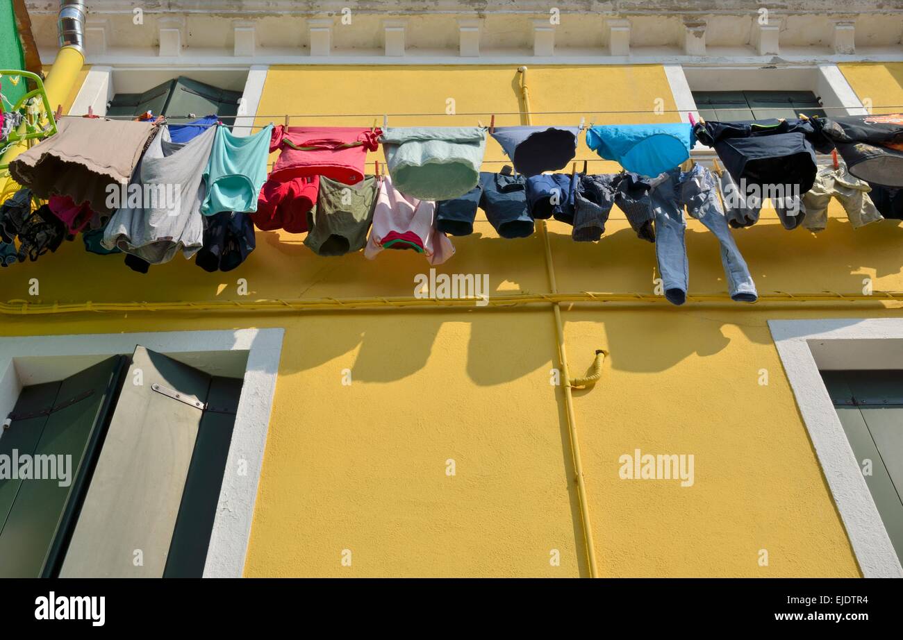 Laundry hanging on yellow house in Burano, an island of the Venetian ...