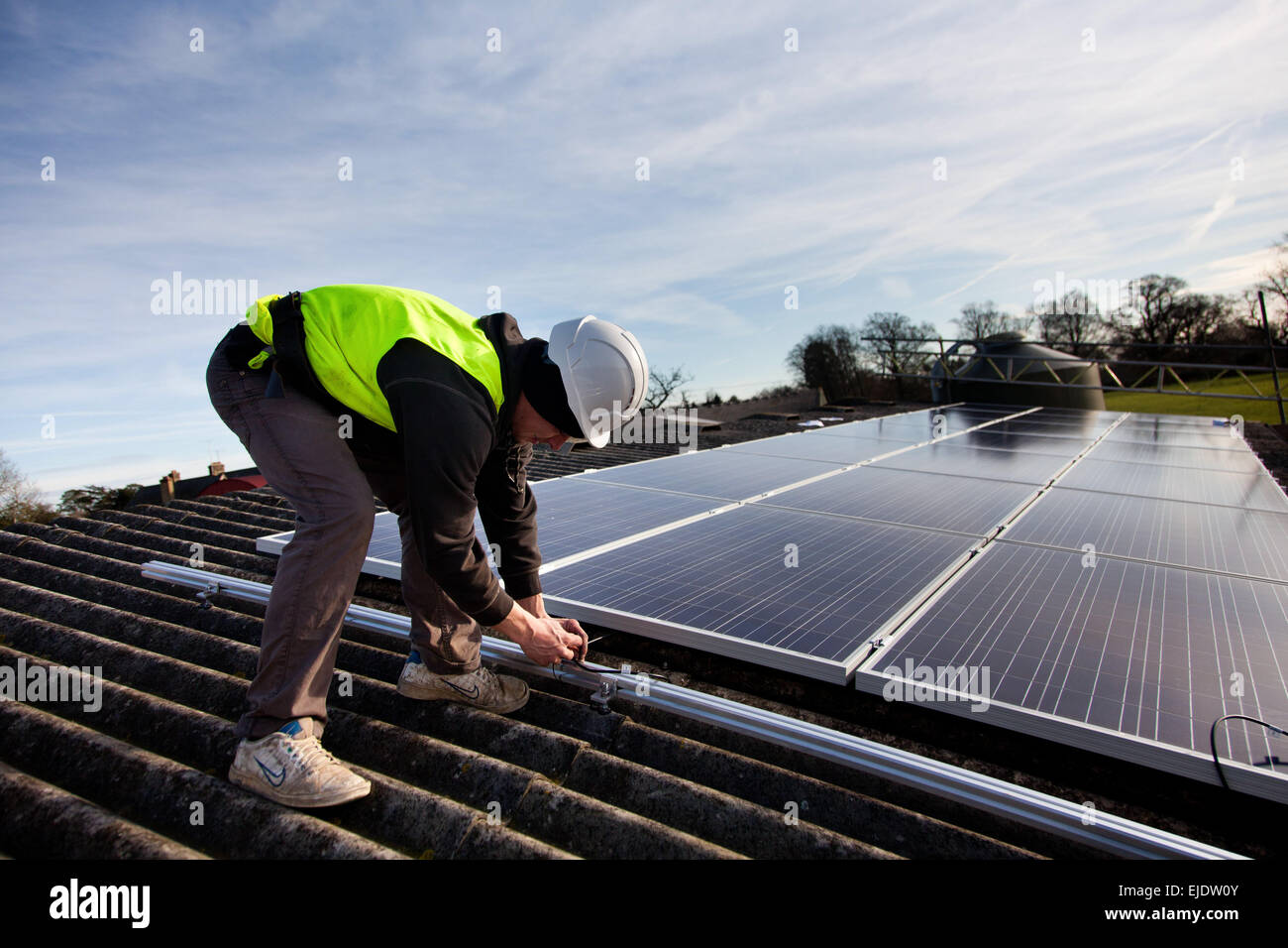Jake Beautyman installs solar panels on a barn roof on Grange farm ...