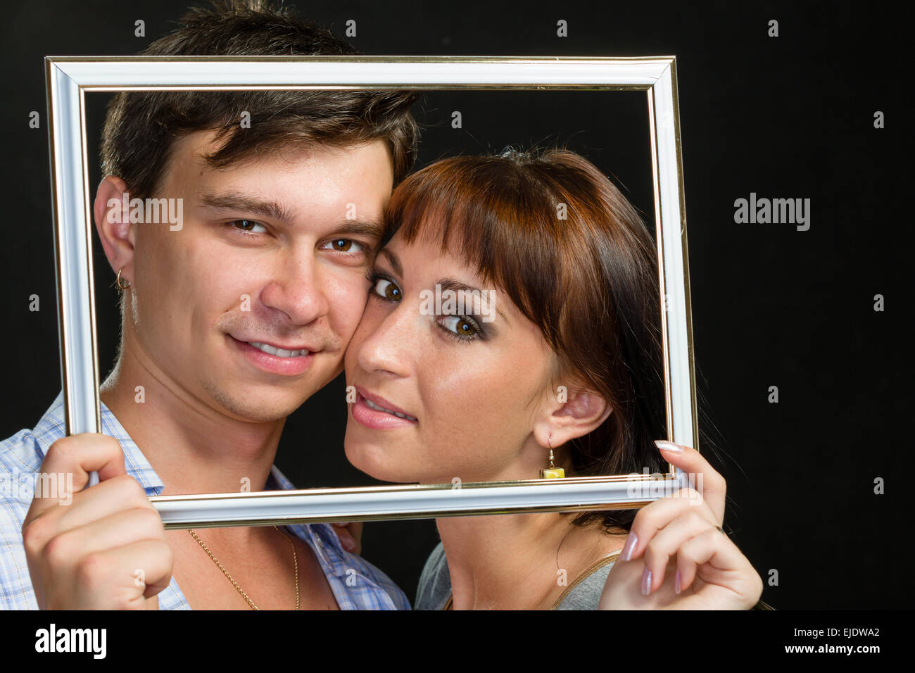Young couple having fun making faces through frame Stock Photo - Alamy