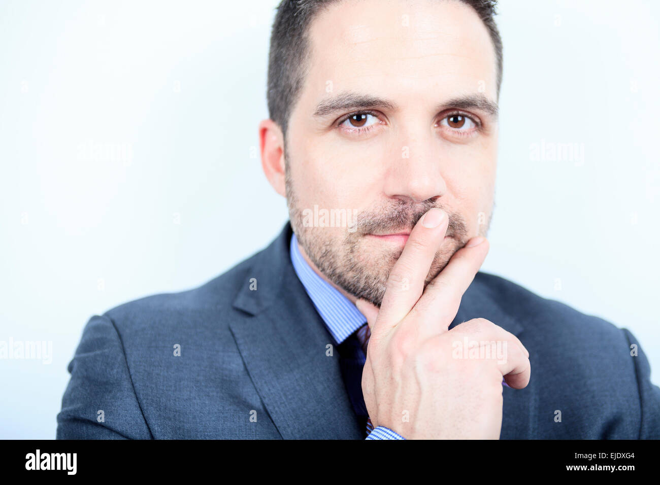 A beautiful business man standing against grey background Stock Photo ...
