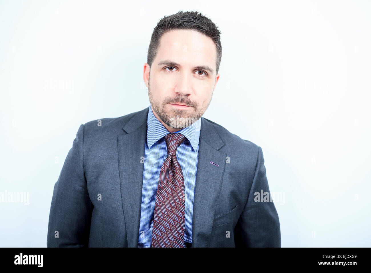 A beautiful business man standing against grey background Stock Photo ...
