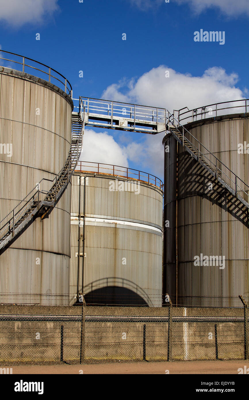 Spiral staircases wrapped around three large oil storage tanks along ...