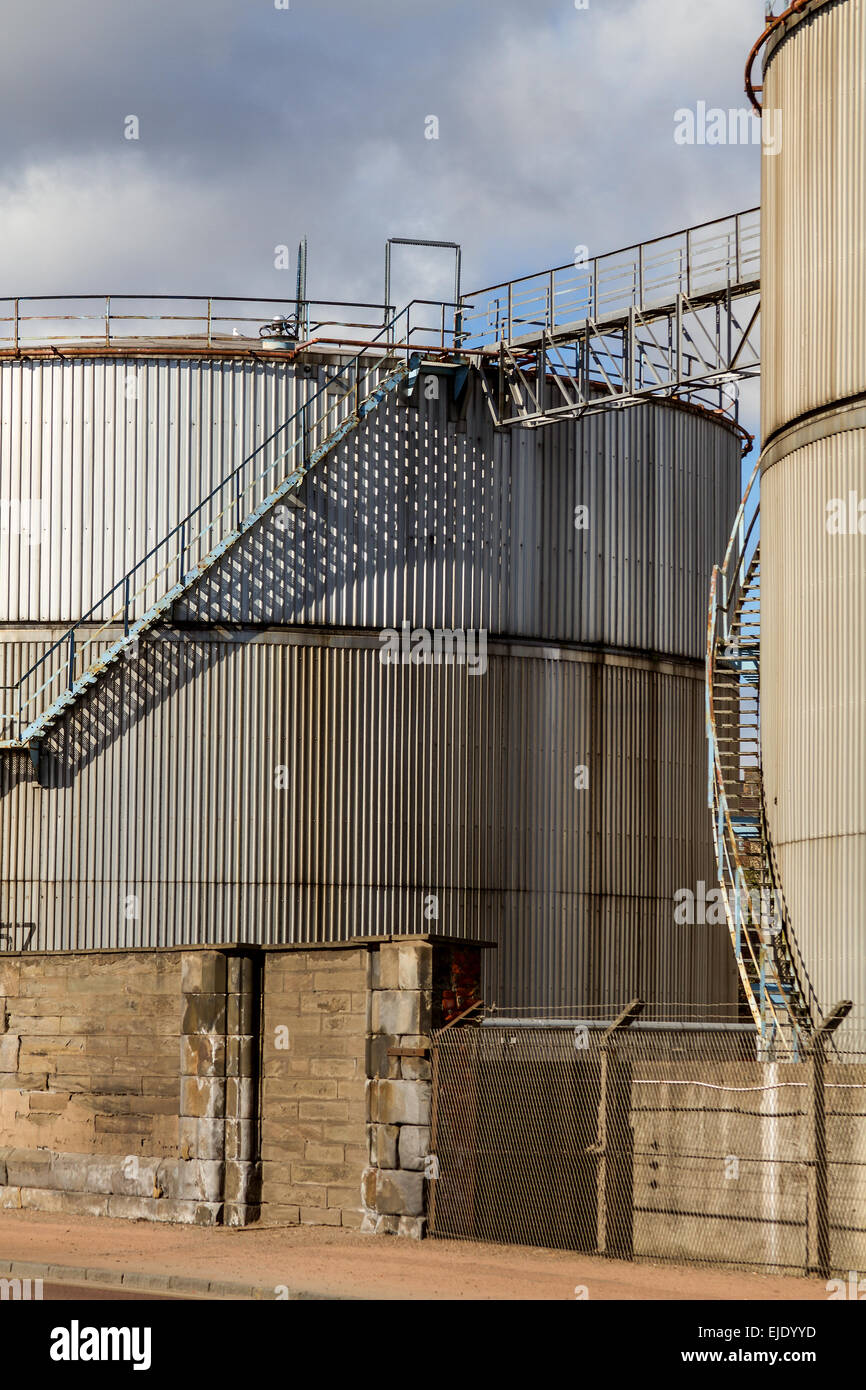 Spiral staircases wrapped around three large oil storage tanks along ...