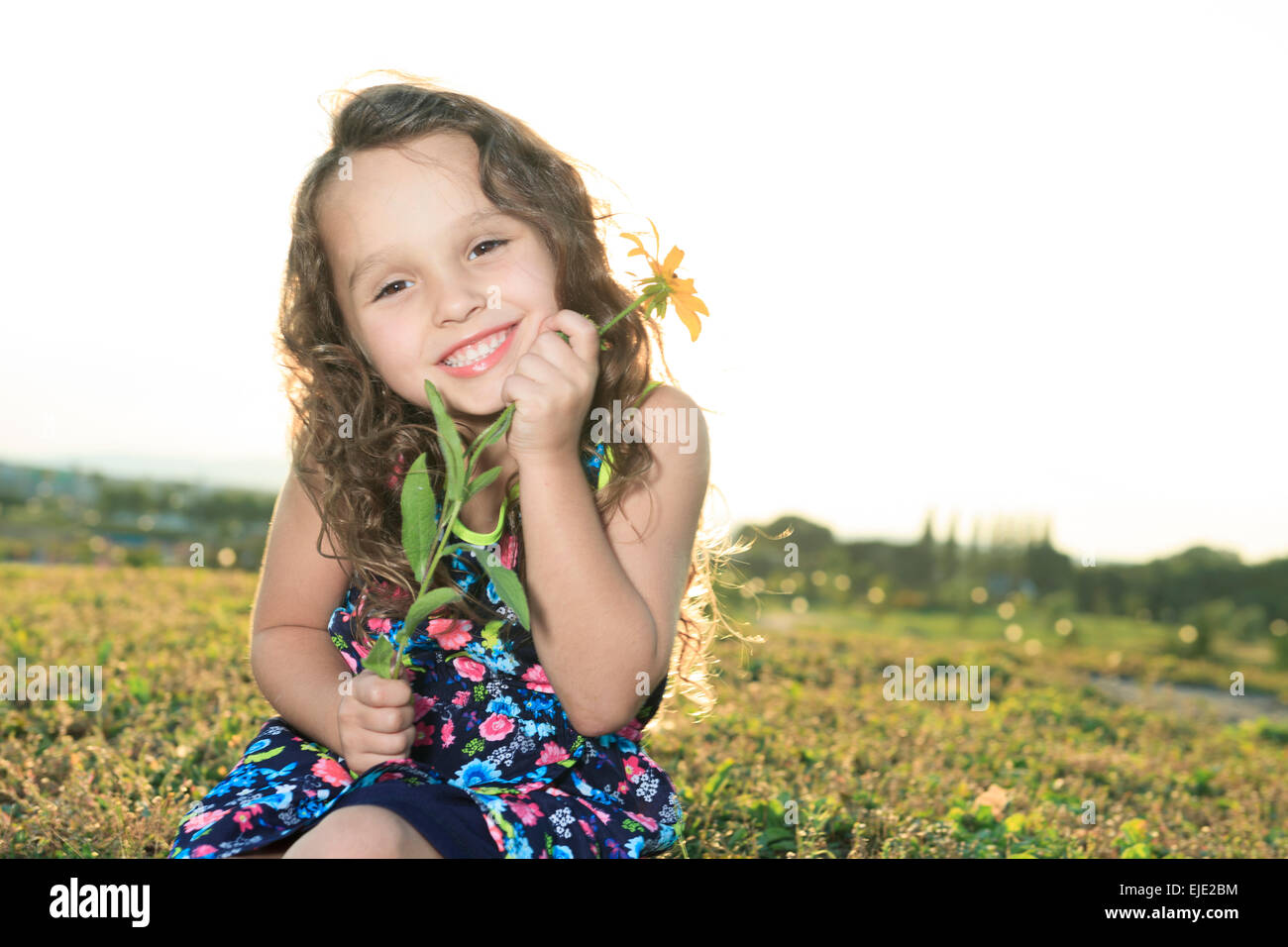 little girl in sunset with flower Stock Photo - Alamy