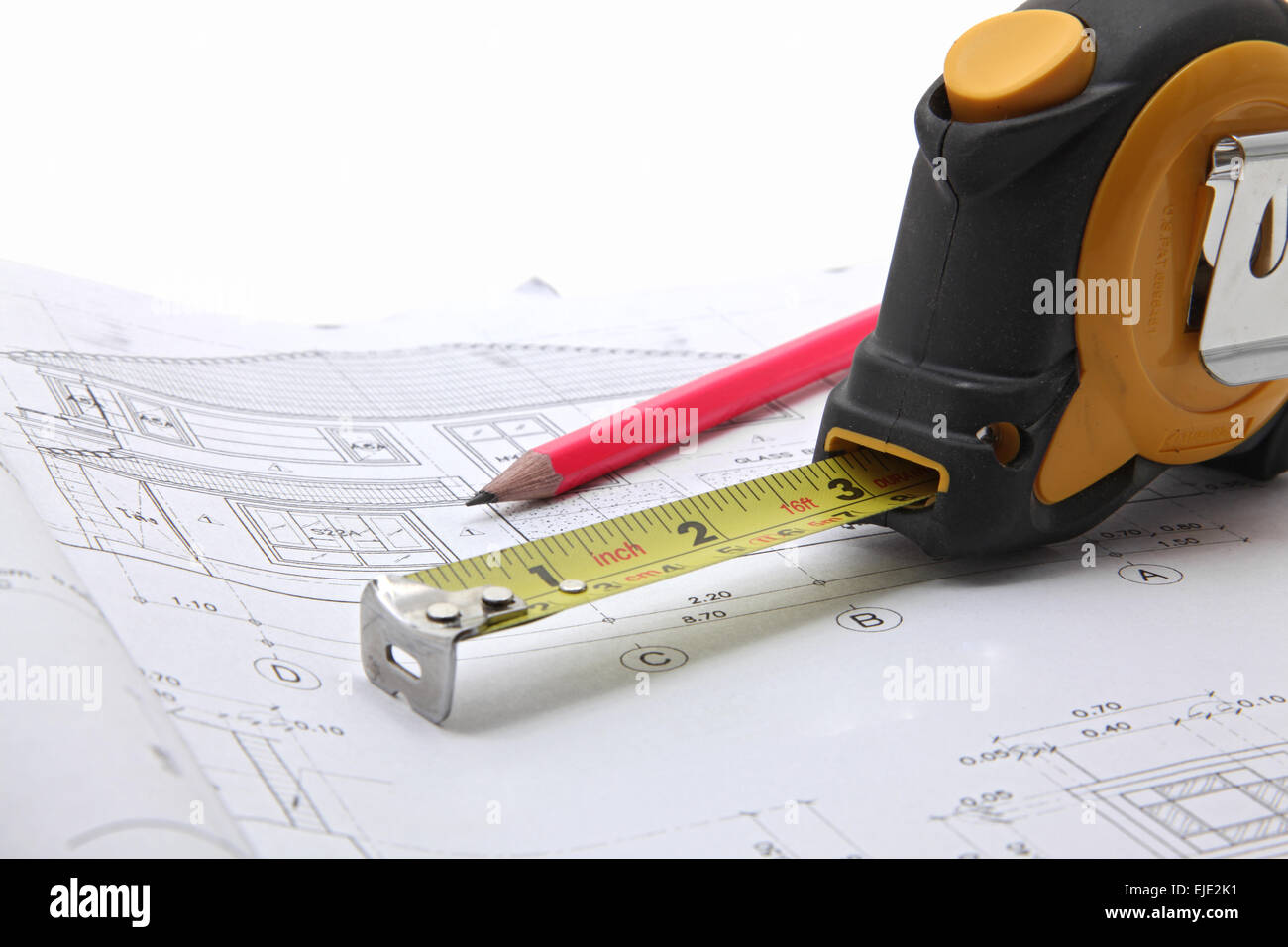 measuring tape and a pencil over a construction blueprint of a house ...