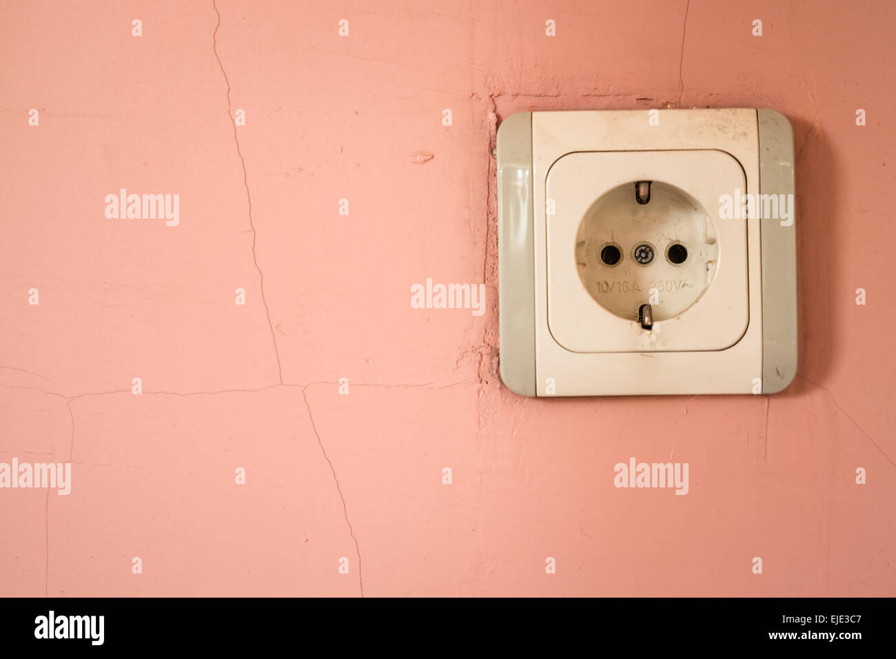 Old and dirty white electricity outlet on pink wall Stock Photo - Alamy