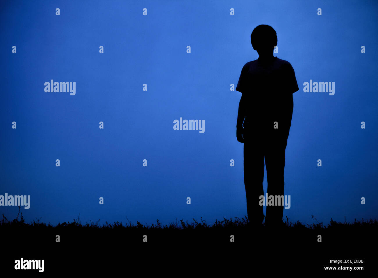 Young boy alone on a background sunrise Stock Photo - Alamy
