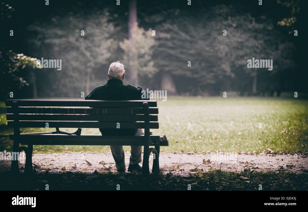 A lonely old man sitting on a bench in a park Stock Photo - Alamy