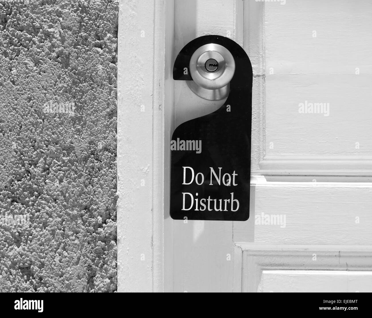 Do not disturb sign hang on door knob and stone wall Stock Photo - Alamy