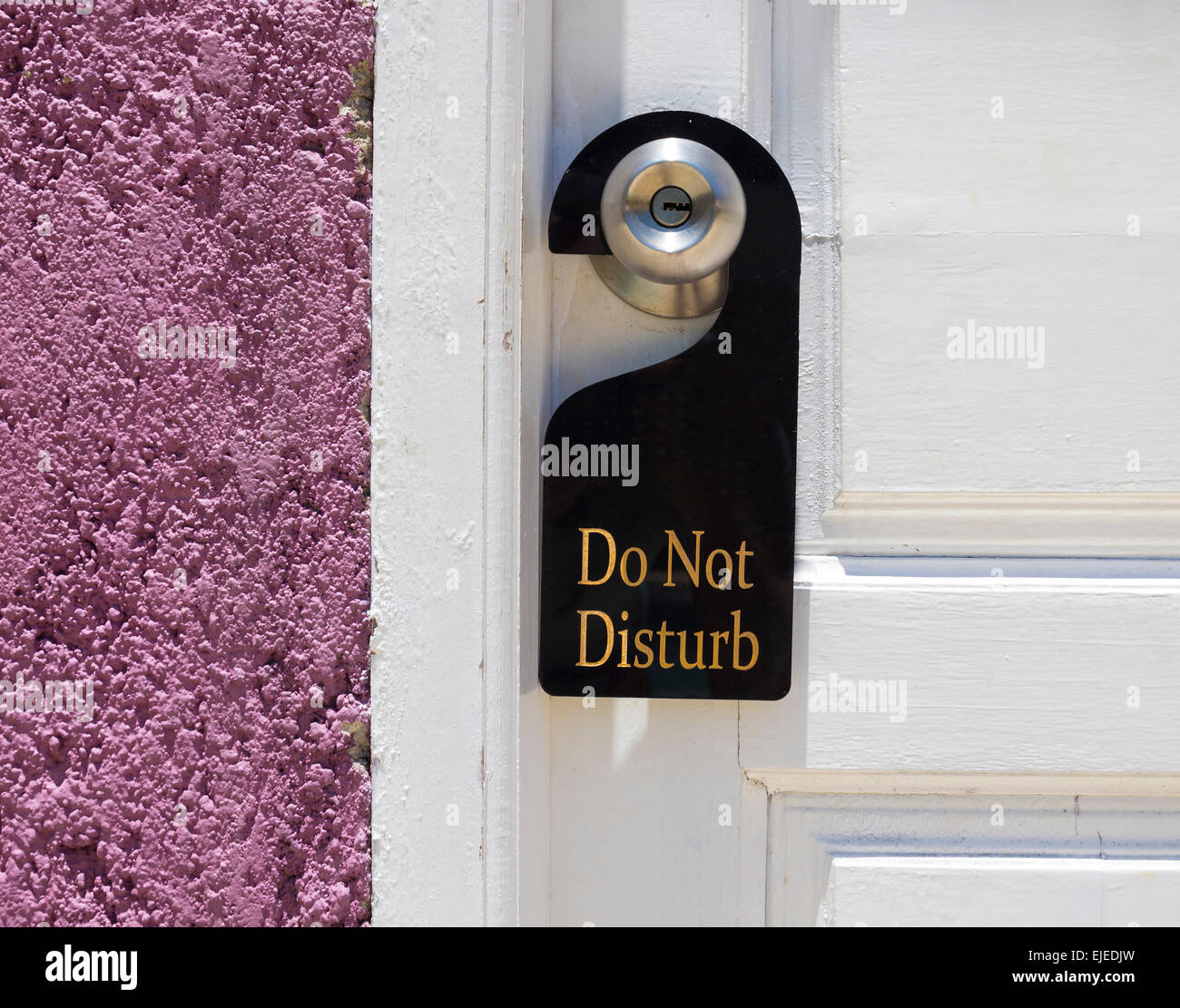 Do not disturb sign hang on door knob and stone wall Stock Photo - Alamy