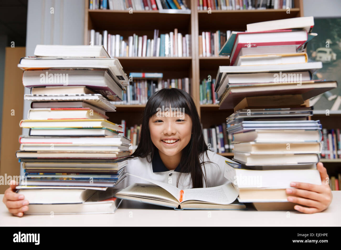 Primary school girls sit pile of books Stock Photo - Alamy