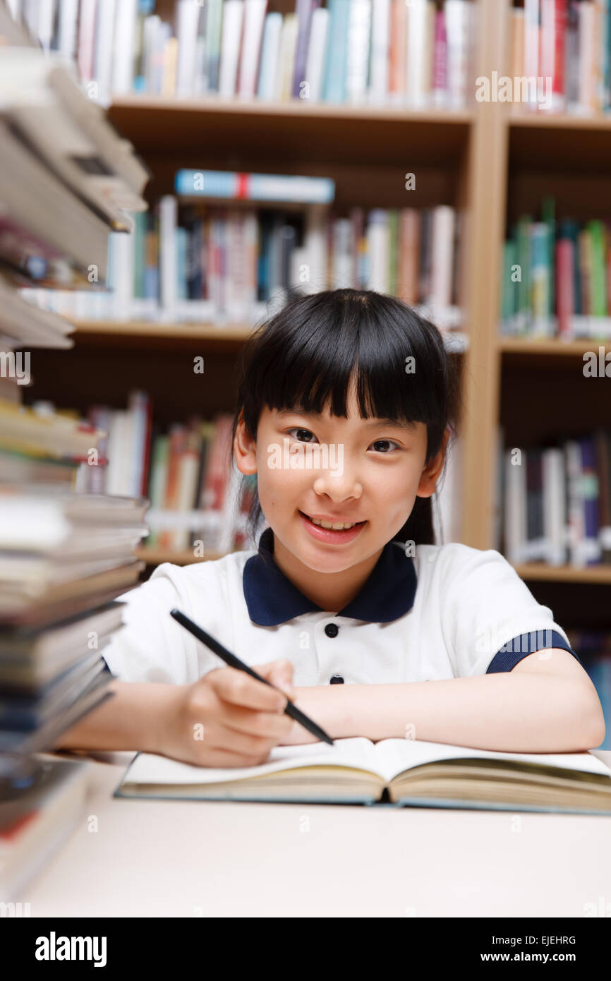 Primary school students learn in the pile of books Stock Photo - Alamy