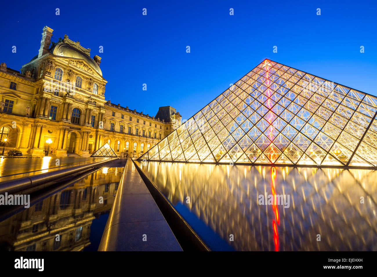 Paris - June 18: Louvre museum at dusk on June 18, 2014 in Paris. This ...