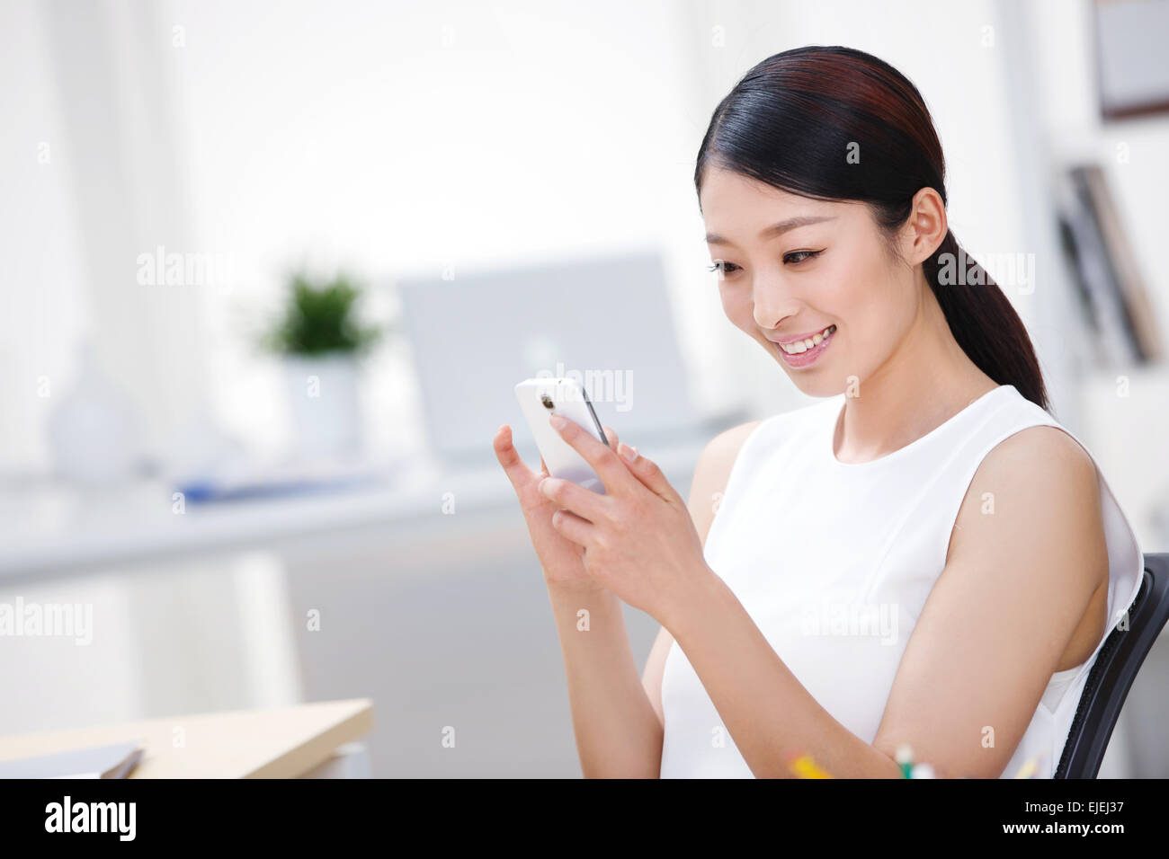 The young business women use mobile phone in the Office Stock Photo - Alamy