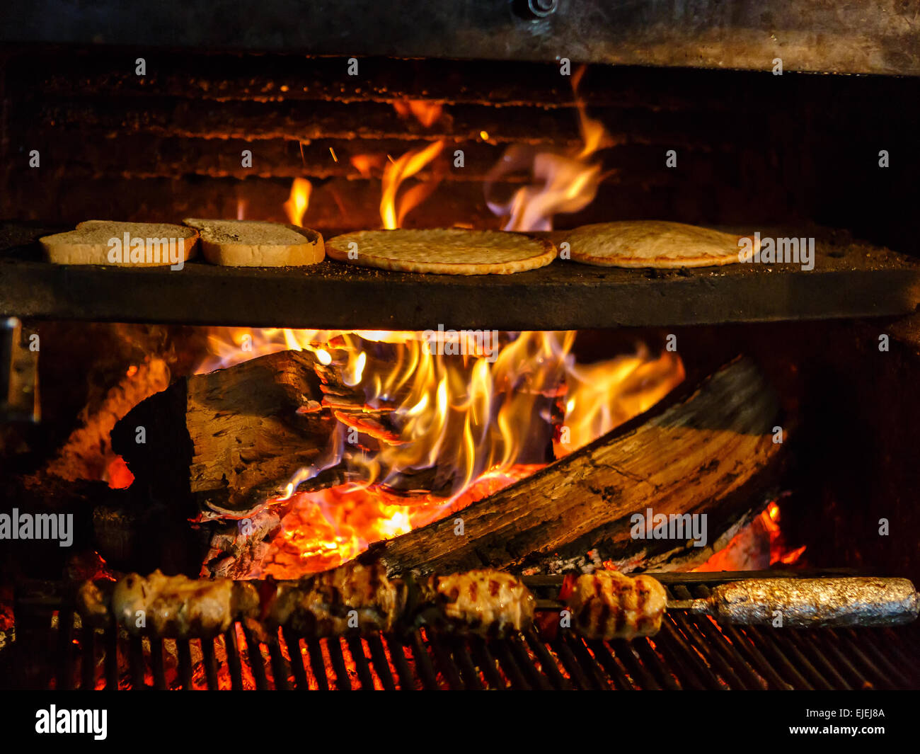 Bread and flat cakes roasted on fire in a fireplace at small Bulgarian ...