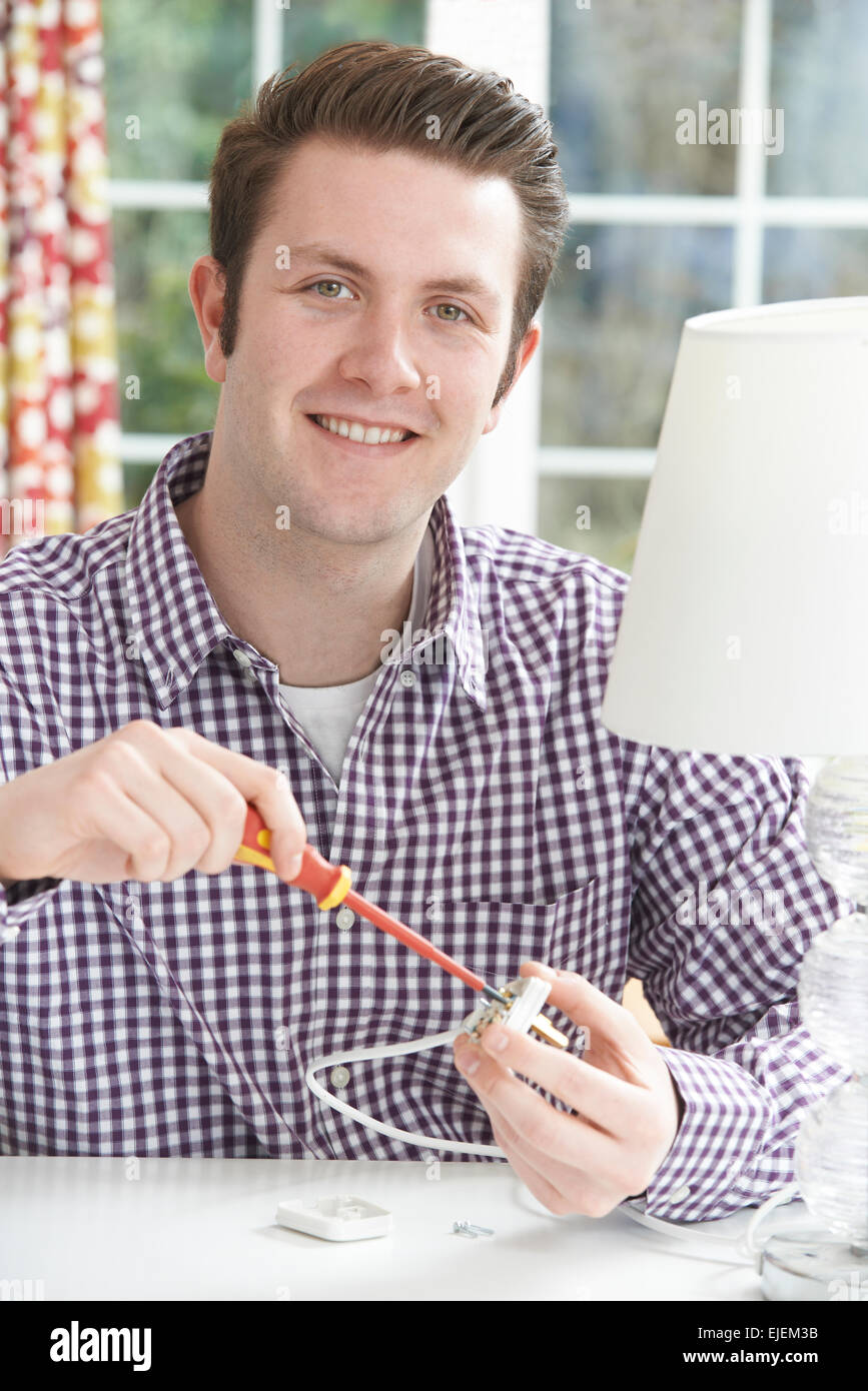 Man Putting Low Energy Lightbulb Into Lamp At Home Stock Photo - Alamy