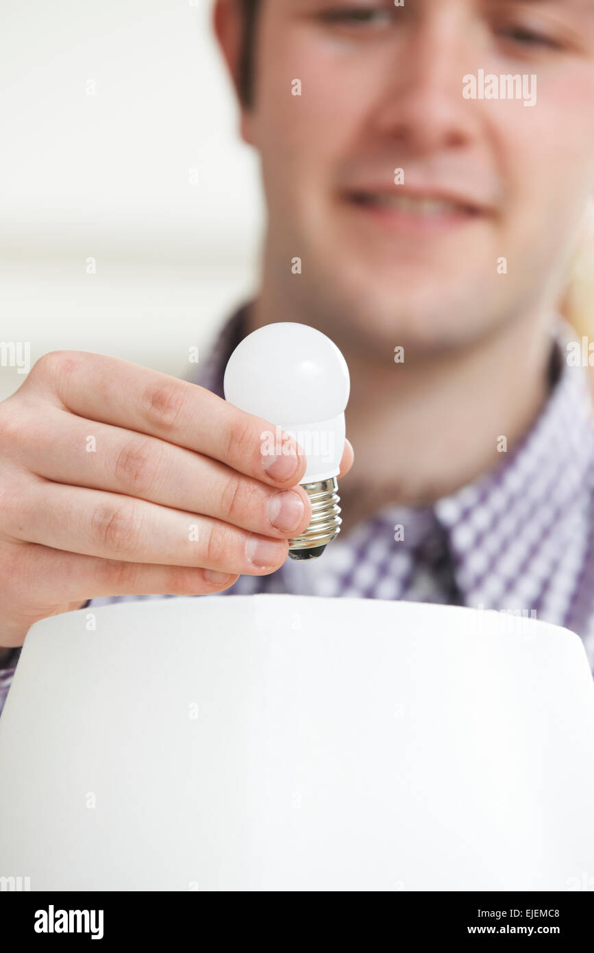 Man Putting Low Energy LED Light bulb Into Lamp At Home Stock Photo - Alamy