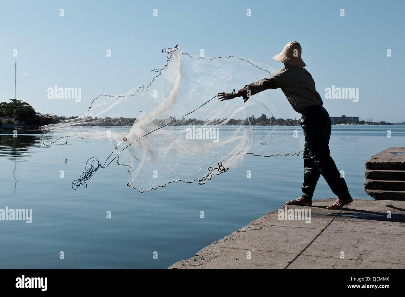 A fisherman casts his net into the sea Stock Photo - Alamy