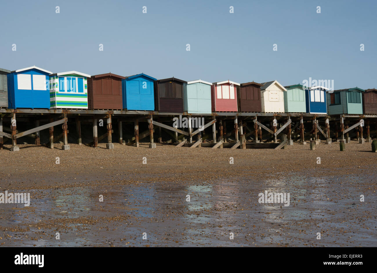 A row of beach huts built on stilts by the sea wall at Frinton-on-sea ...