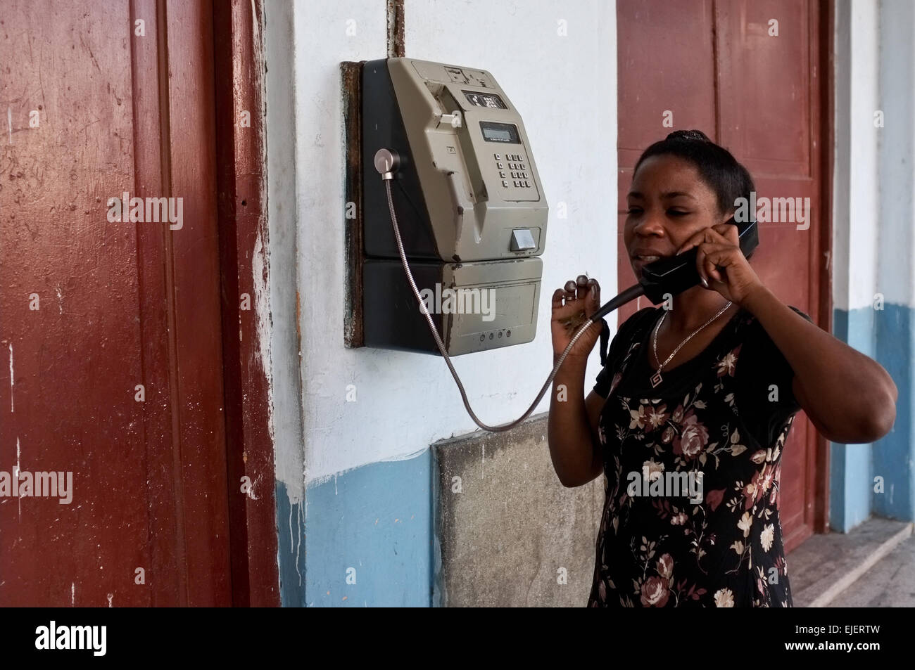 A woman speaks on a public phone on a Havana street. Mobile phones were ...