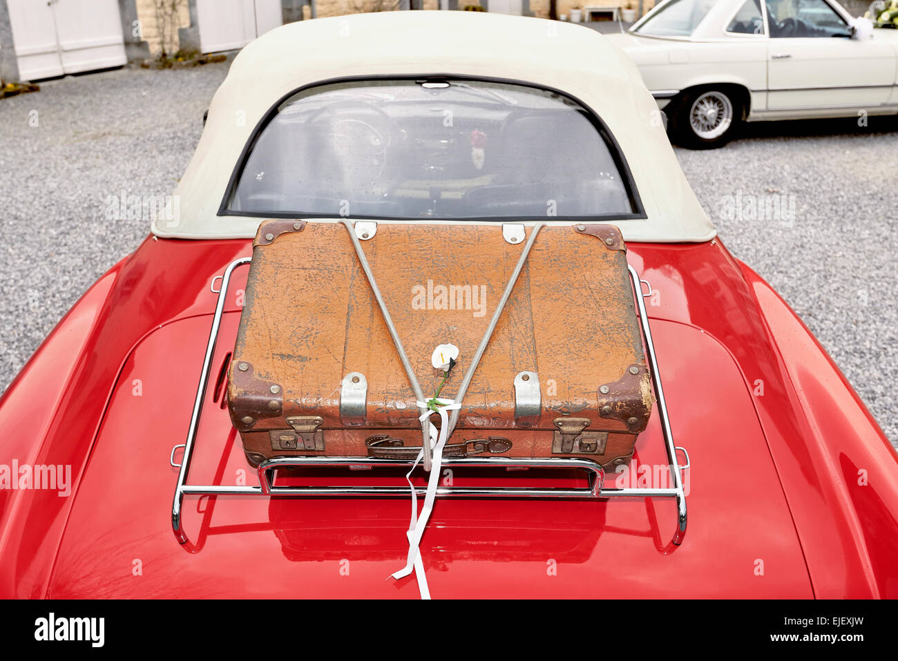 Suitcase placed on the trunk of a red car Stock Photo - Alamy