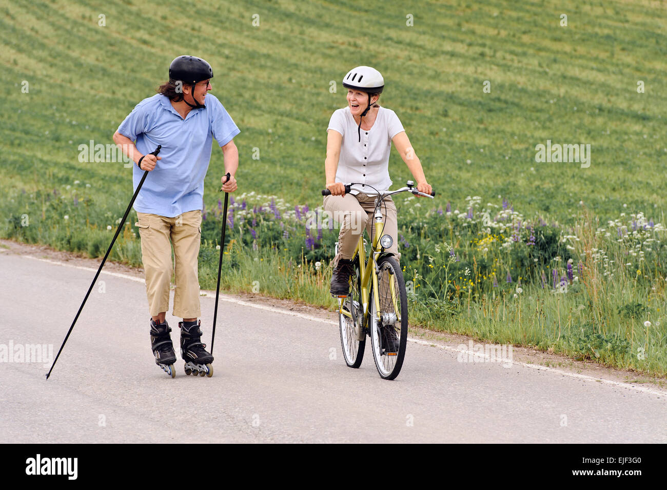 Senior couple vigorously exercising. The man is Nordic inline skating ...