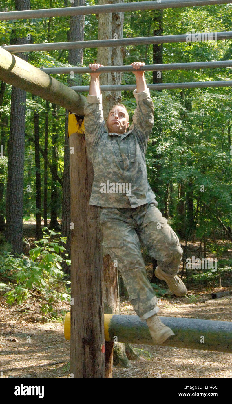 Sgt. 1st Class Brian Eisch negotiates a cross bar obstacle during the ...